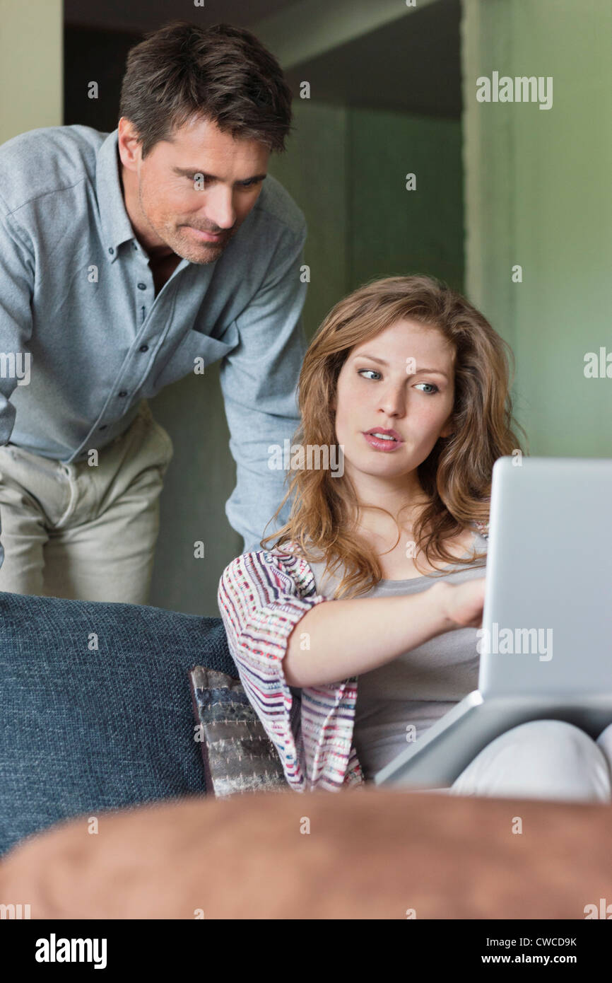 Couple using a laptop at home Stock Photo - Alamy