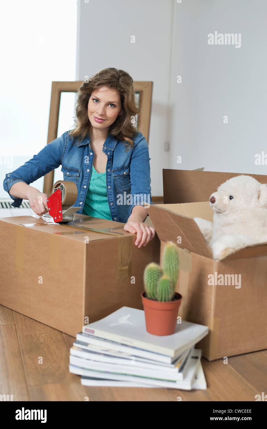 Woman taping up cardboard box Stock Photo - Alamy