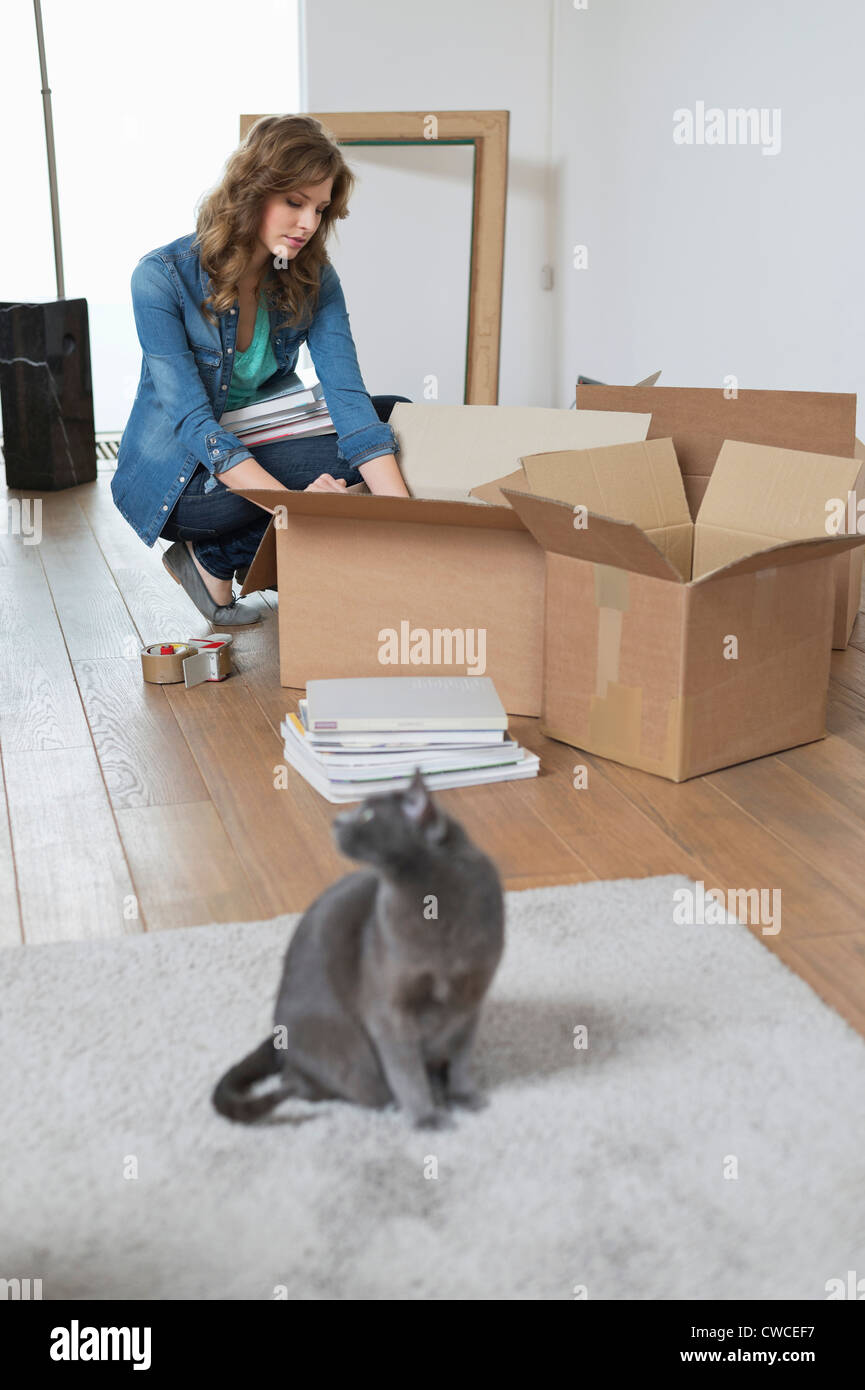 Woman putting books in a cardboard box Stock Photo - Alamy