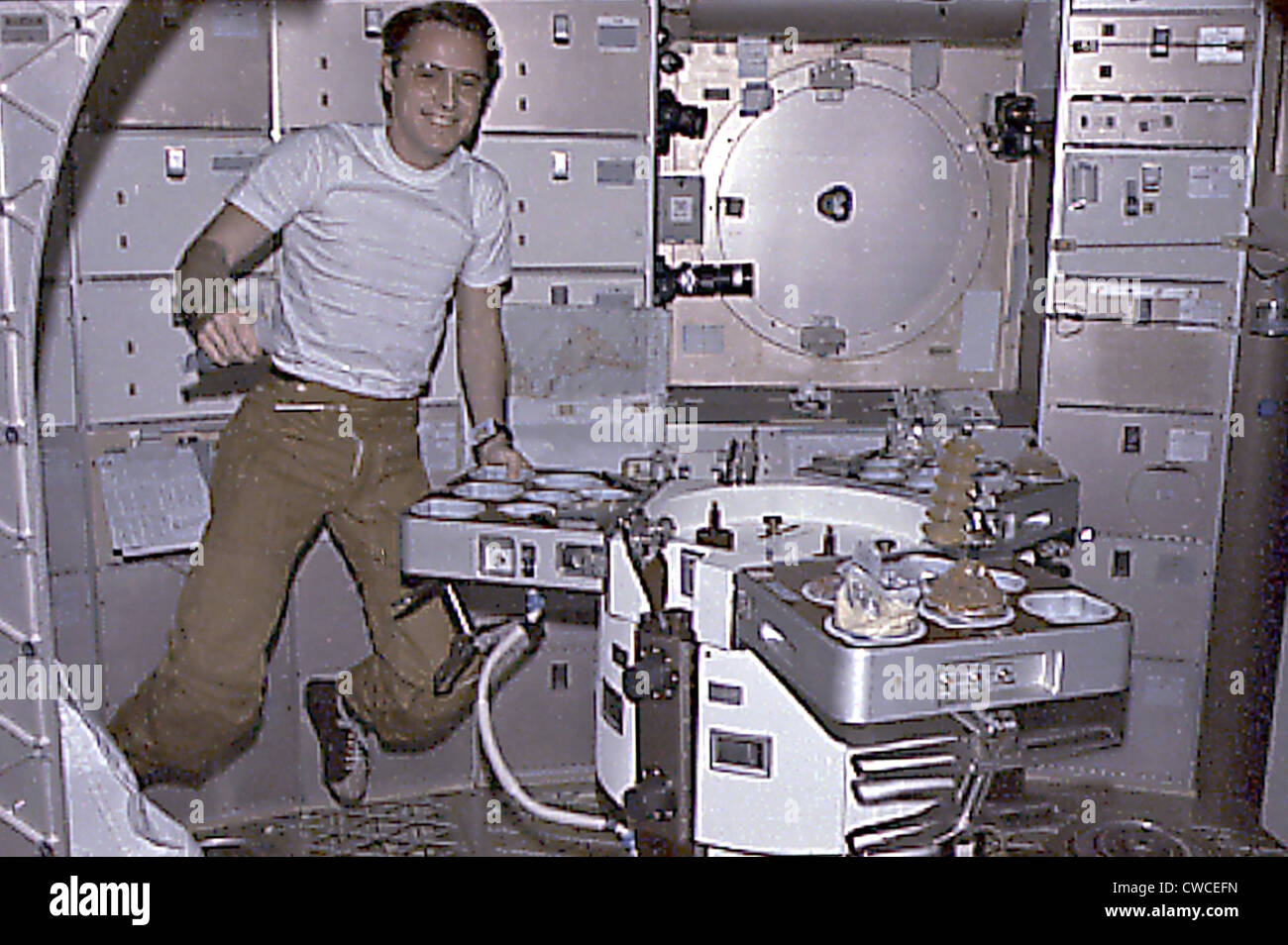 Skylab 4 Astronaut Ed Gibson preparing his meal aboard the Skylab space ...