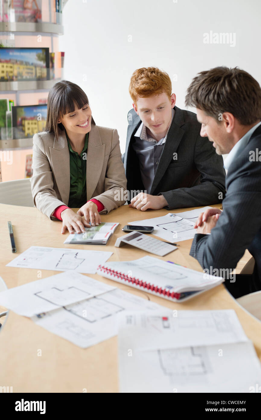 Real estate agent discussing property documents to his clients Stock ...