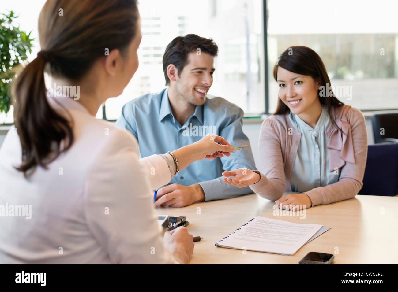 Couple receiving keys from real estate agent Stock Photo - Alamy