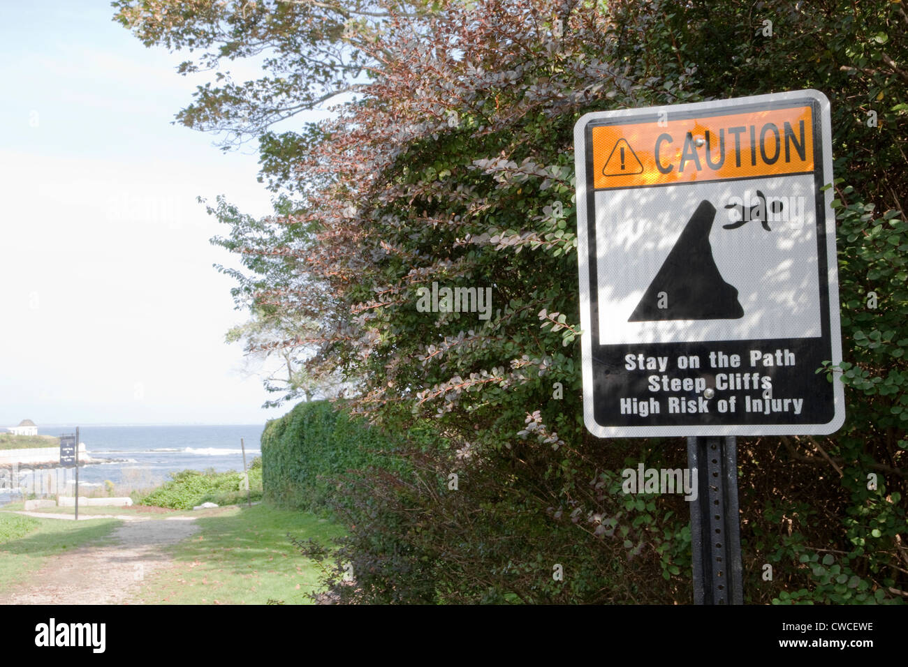 A caution sign instructing people to stay on a steep cliff path to ...