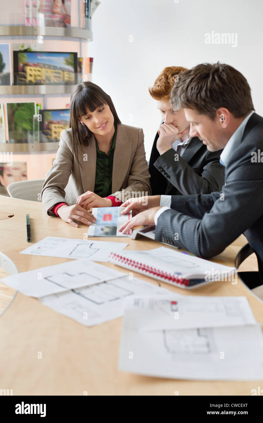 Real estate agent discussing property documents to his clients Stock ...