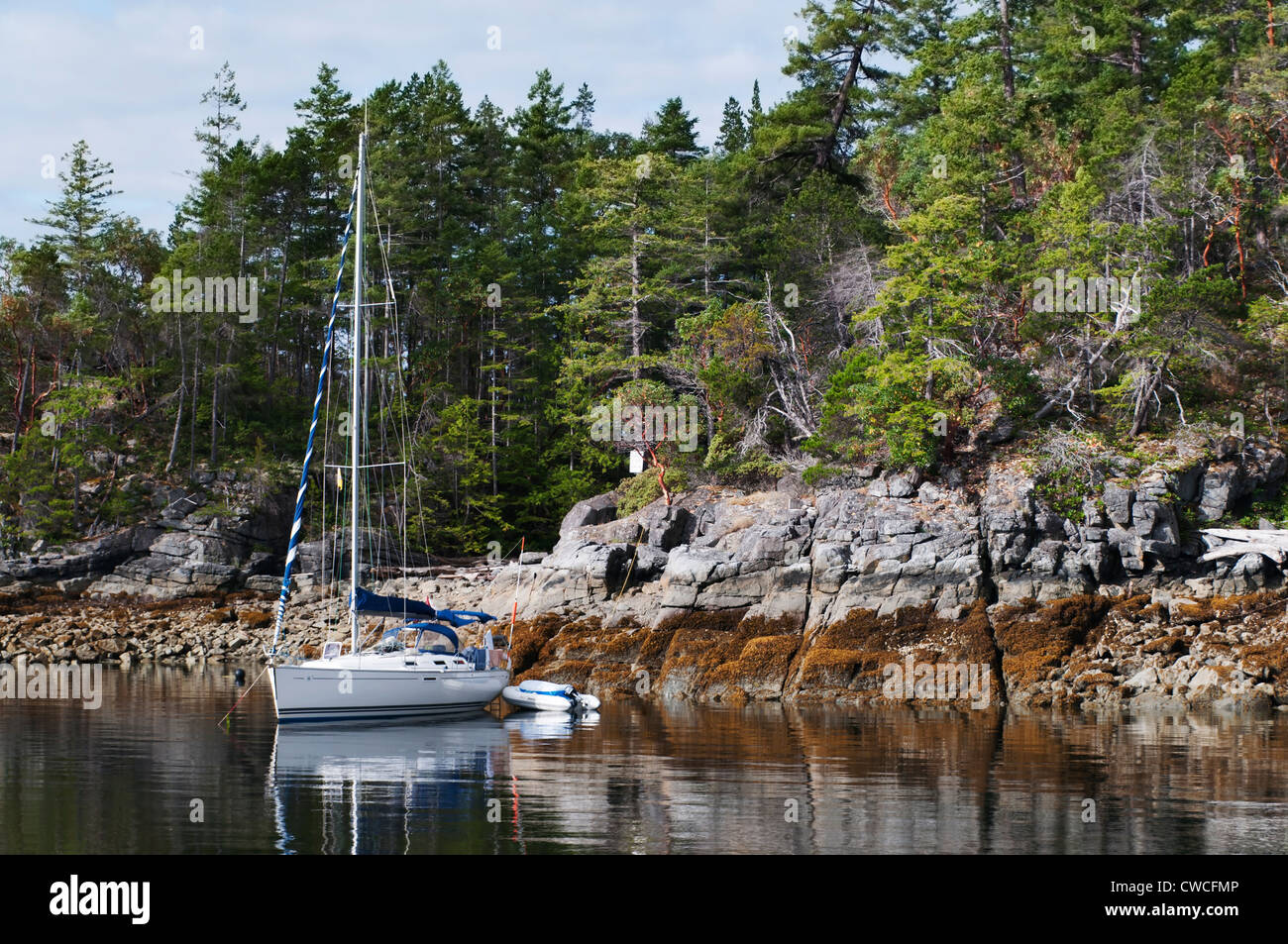 A sailboat is anchored along the shoreline of Mink Island in Canada's ...