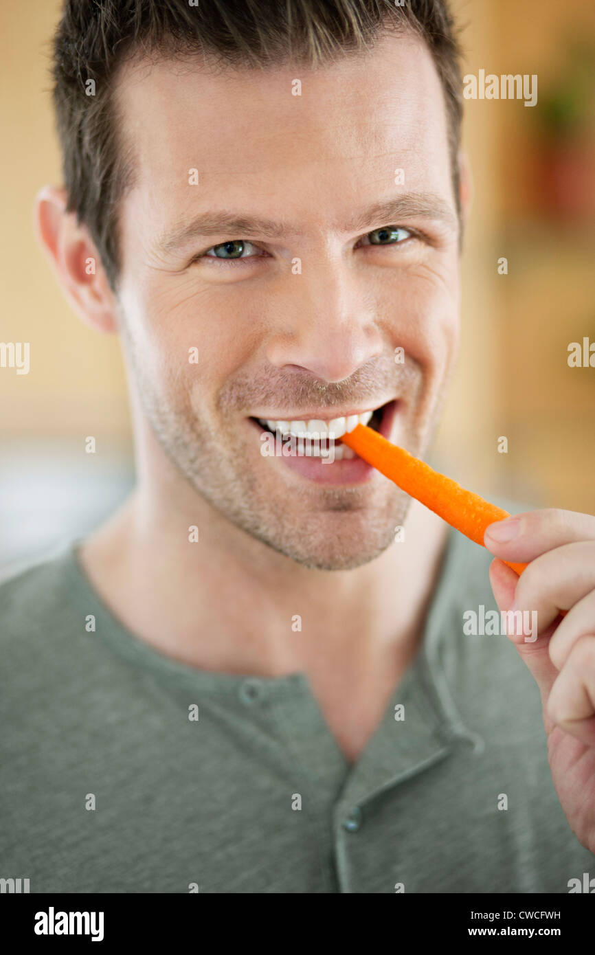 Man eating a carrot Stock Photo - Alamy