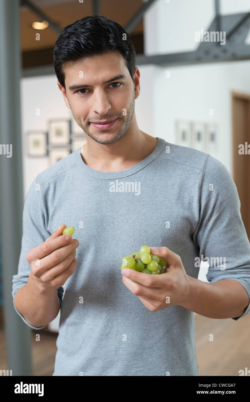 Portrait of a man eating grapes Stock Photo - Alamy