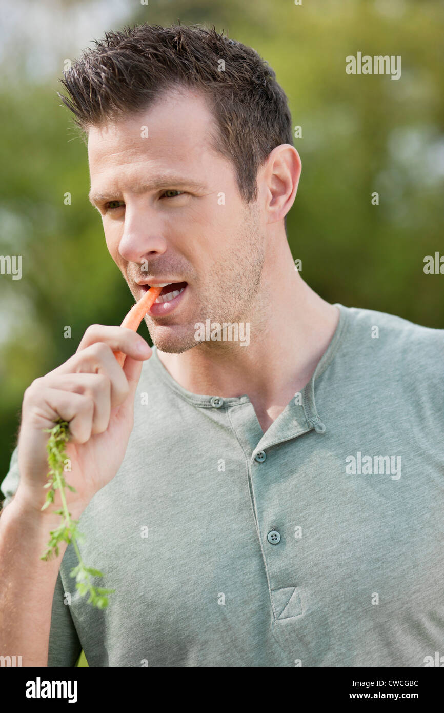 Man eating a carrot Stock Photo - Alamy