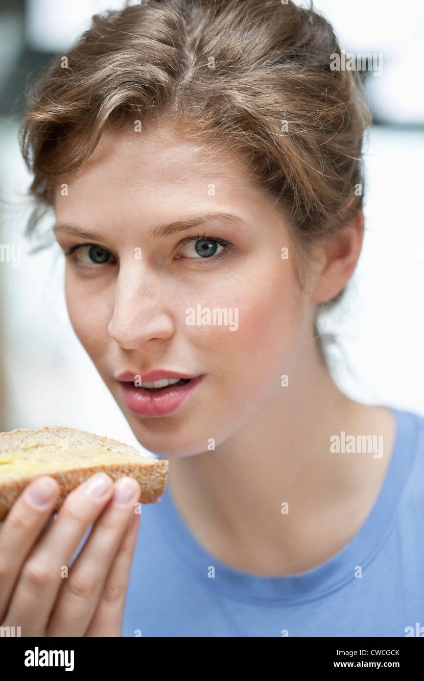 Portrait of a woman eating a bread Stock Photo - Alamy