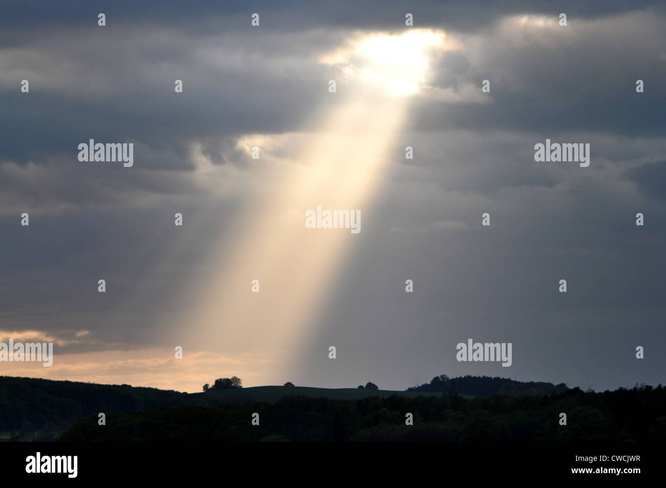 A ray of sunlight breaking through dark clouds Stock Photo - Alamy
