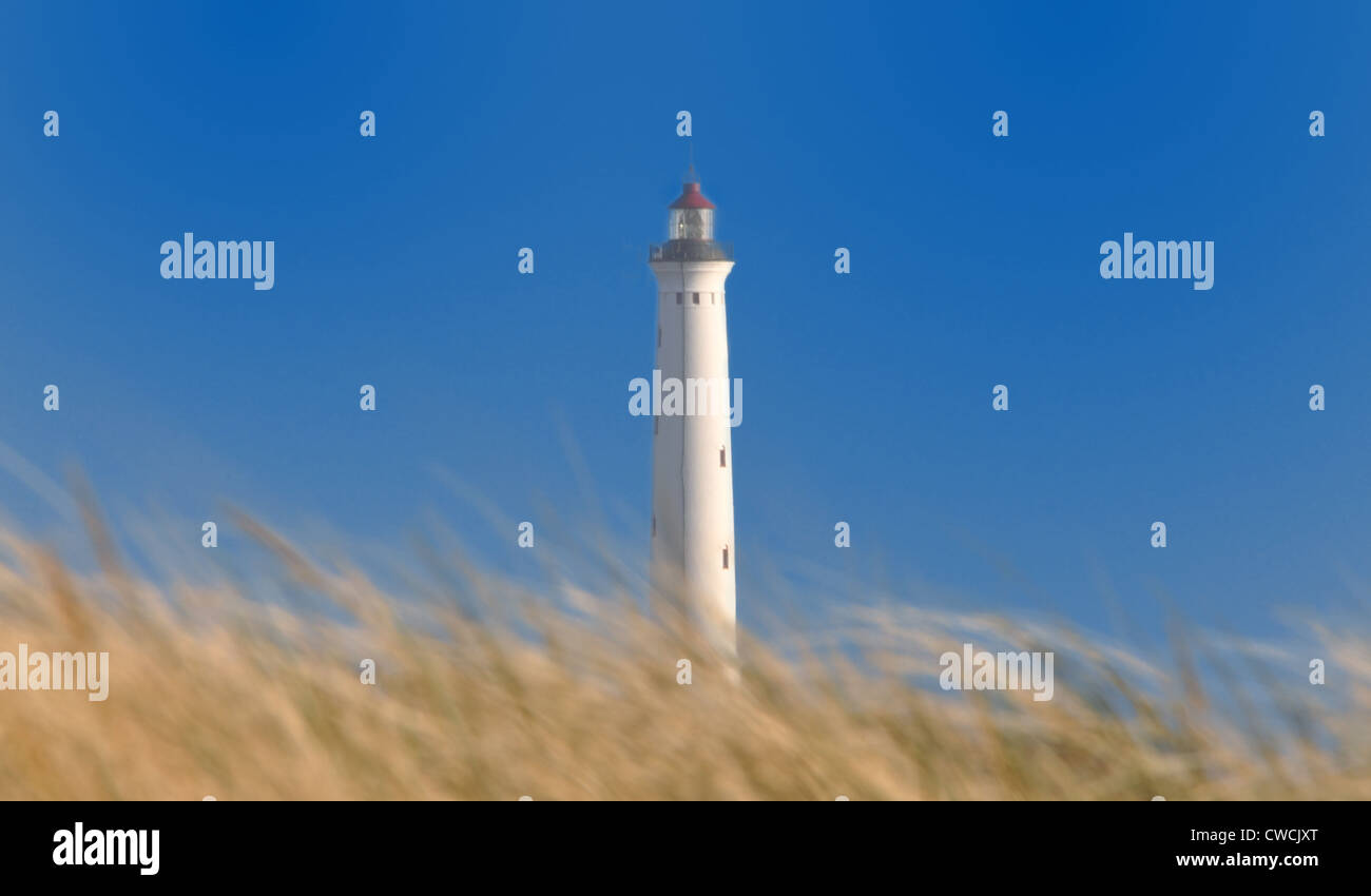 A white lighthouse behind a dune Stock Photo - Alamy