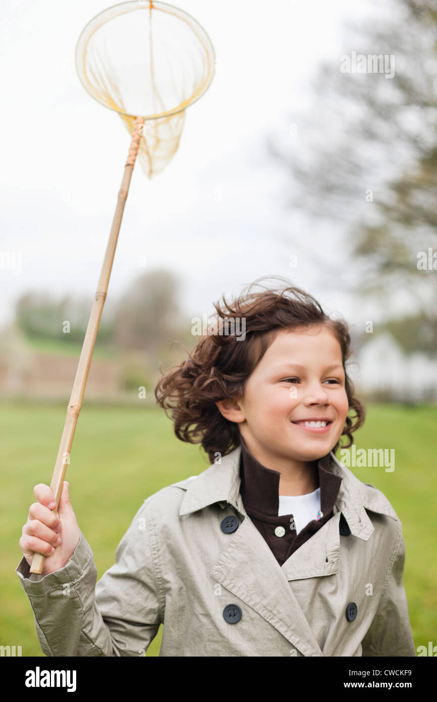 Boy running with a butterfly net in a park Stock Photo - Alamy