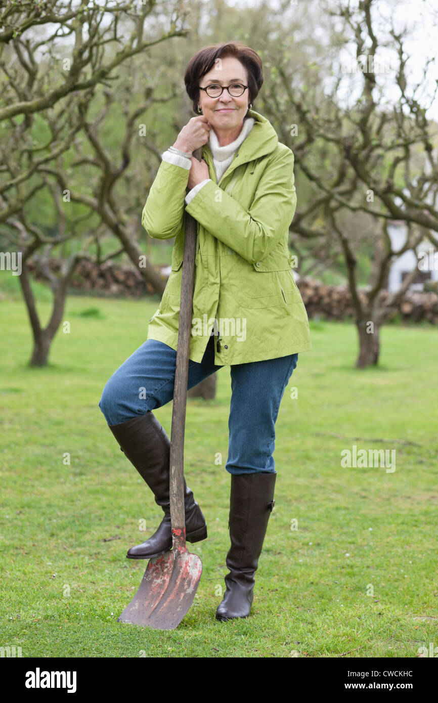 Woman standing with a shovel Stock Photo - Alamy