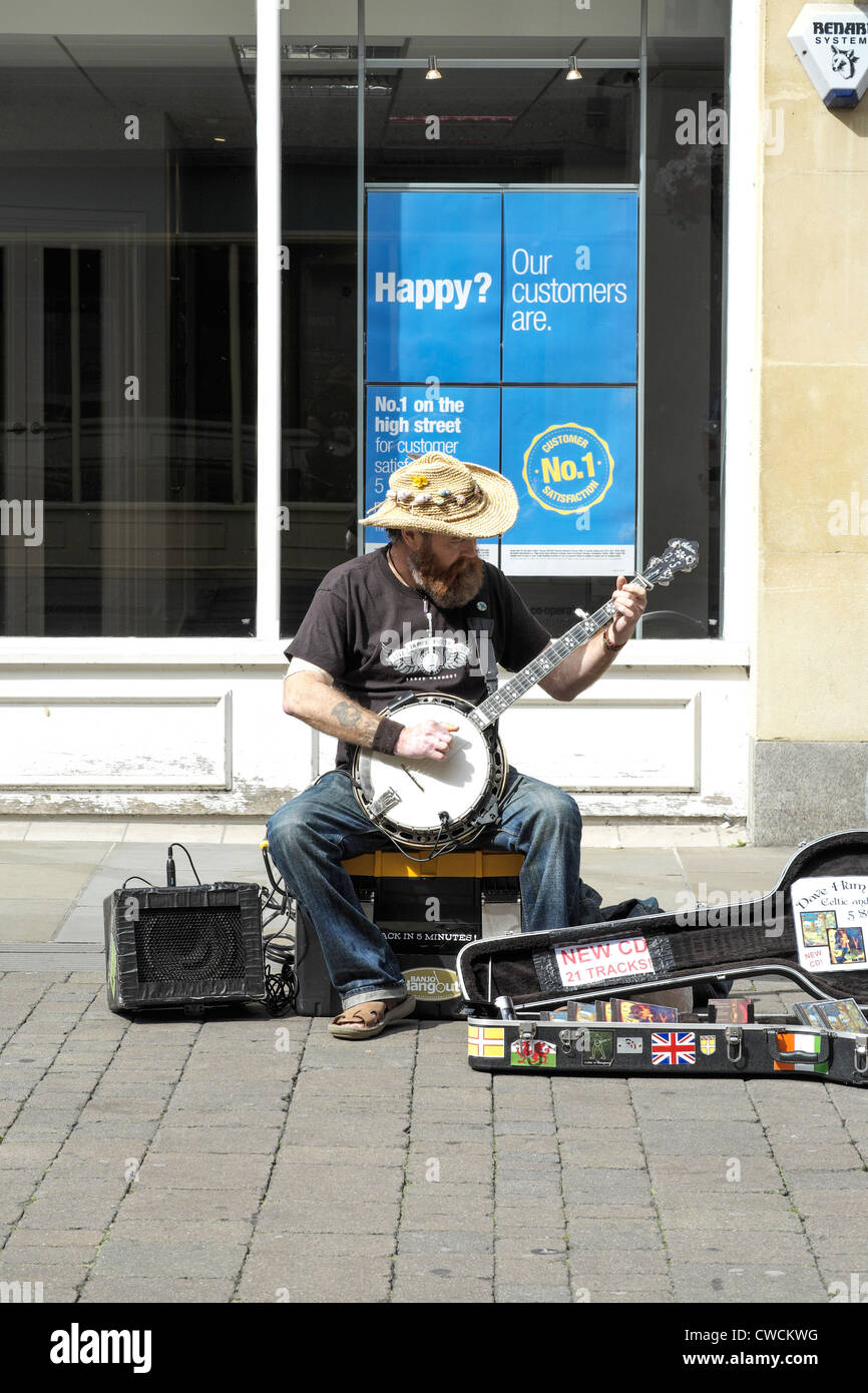 Busker playing banjo in UK high street Stock Photo - Alamy