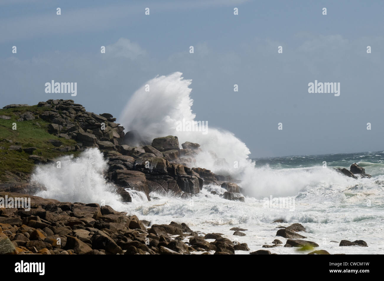 A large wave created by strong winds and a stormy sea crashes against ...