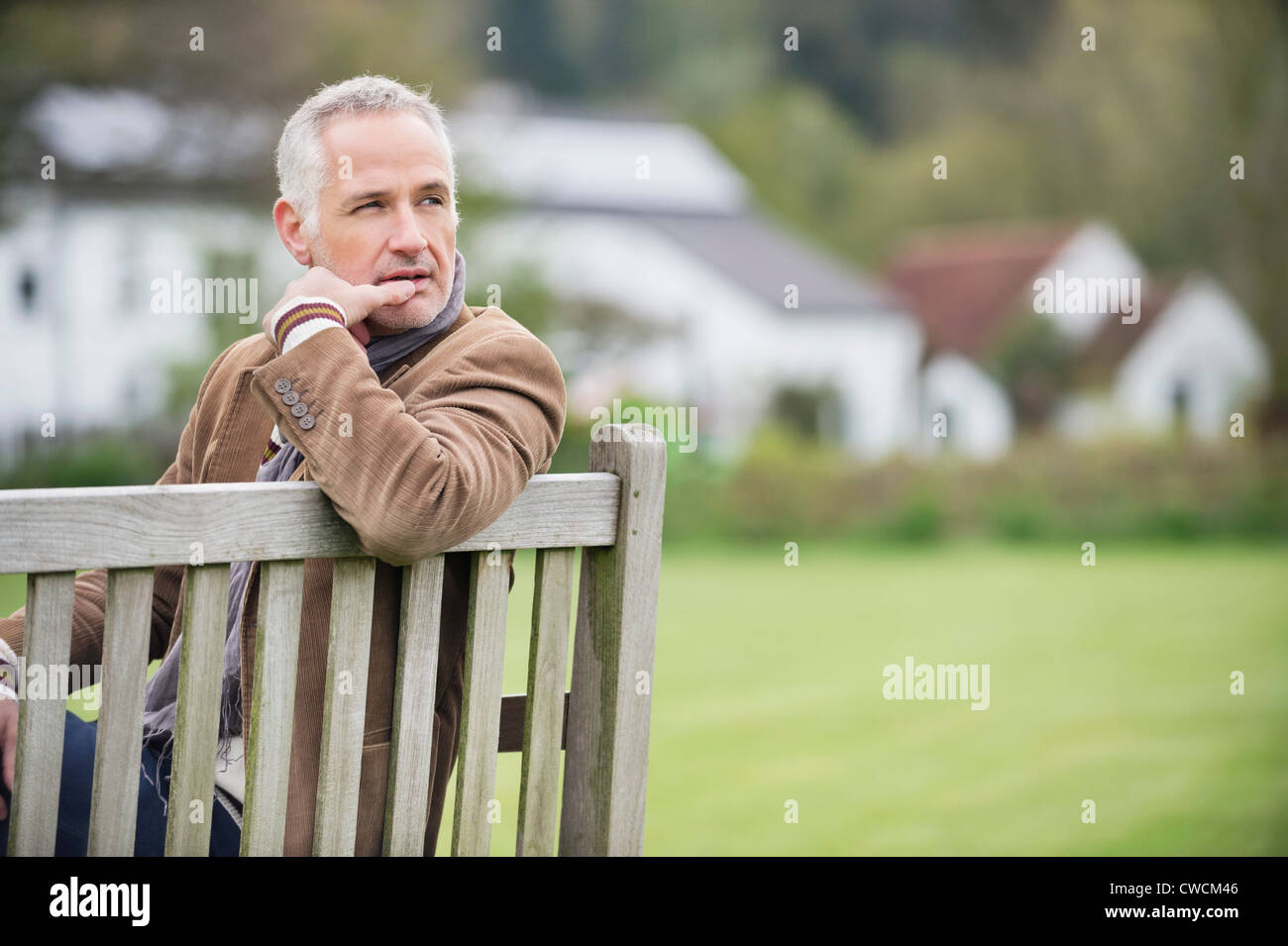 Man sitting on a bench and thinking in a park Stock Photo - Alamy