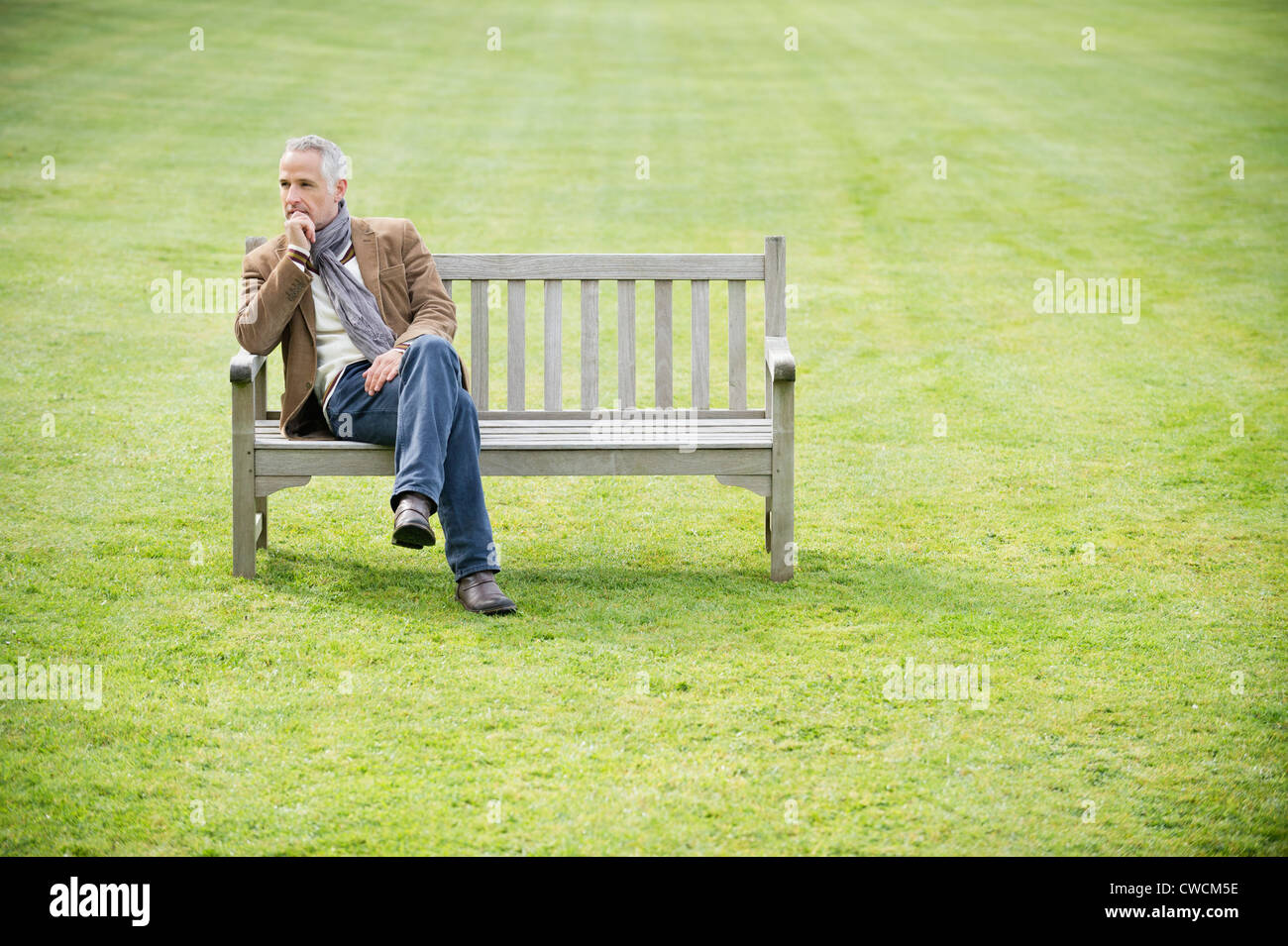 Man sitting on a bench and thinking in a park Stock Photo - Alamy