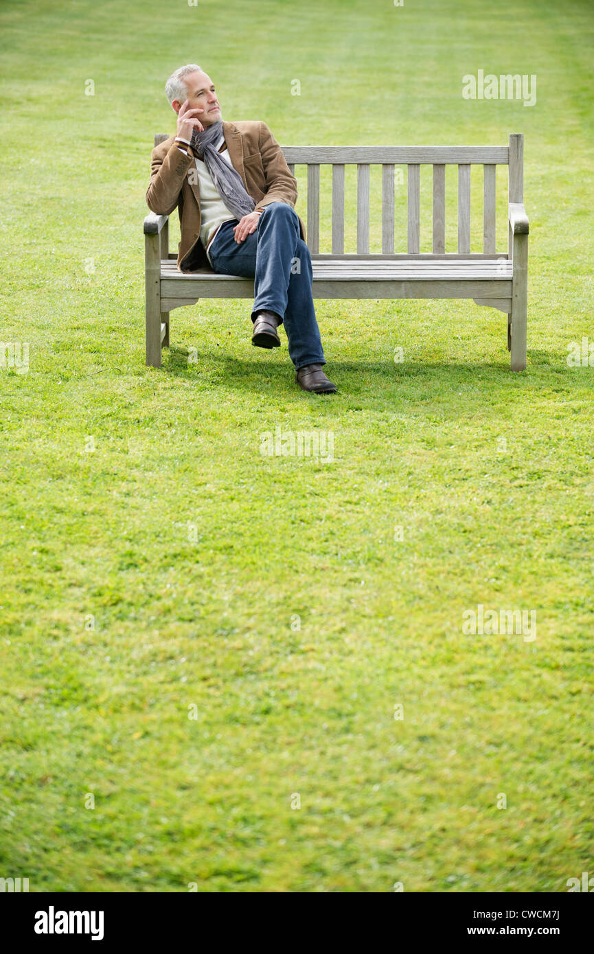 Man sitting on a bench and thinking in a park Stock Photo - Alamy