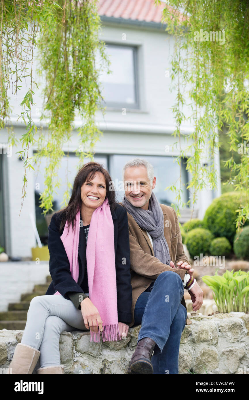 Romantic couple sitting in a garden and smiling Stock Photo - Alamy