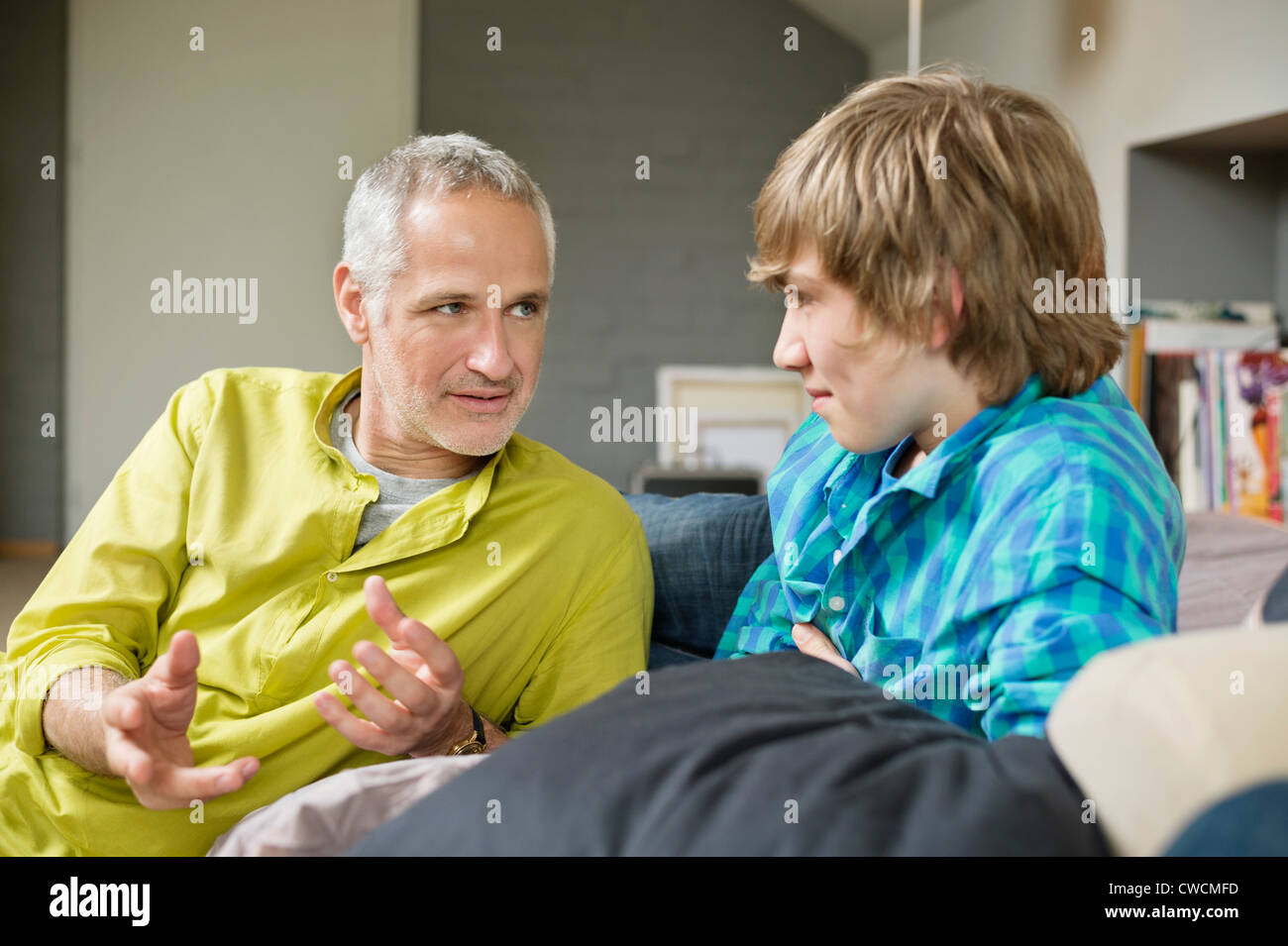 Man talking with his son at home Stock Photo - Alamy