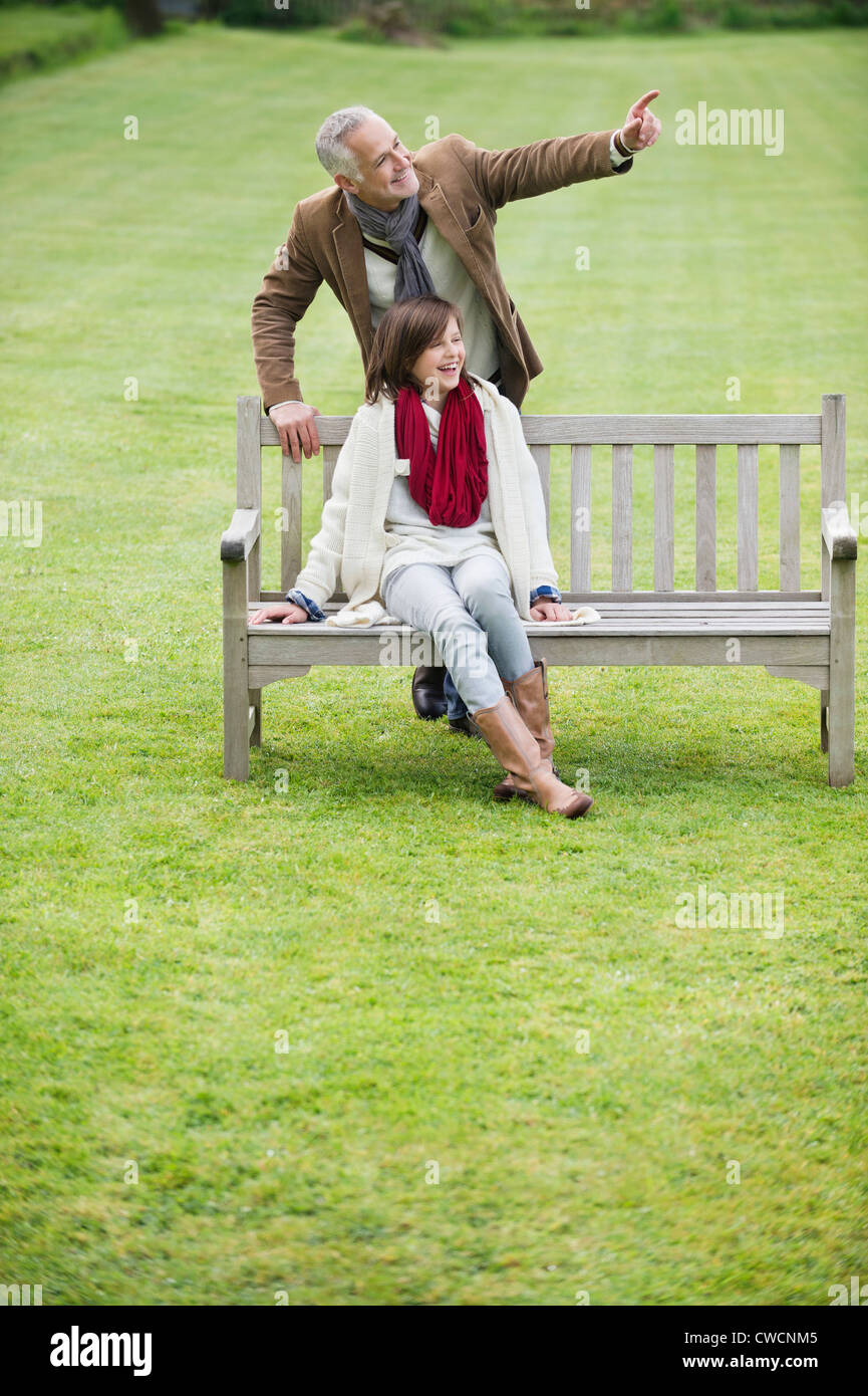 Man sitting with his daughter on a bench and pointing in a park Stock ...