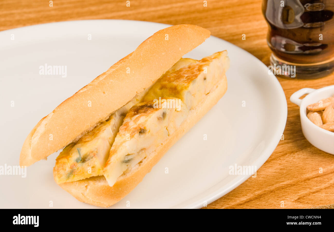 A fresh potato tortilla stuffing a traditional Spanish baguette Stock ...