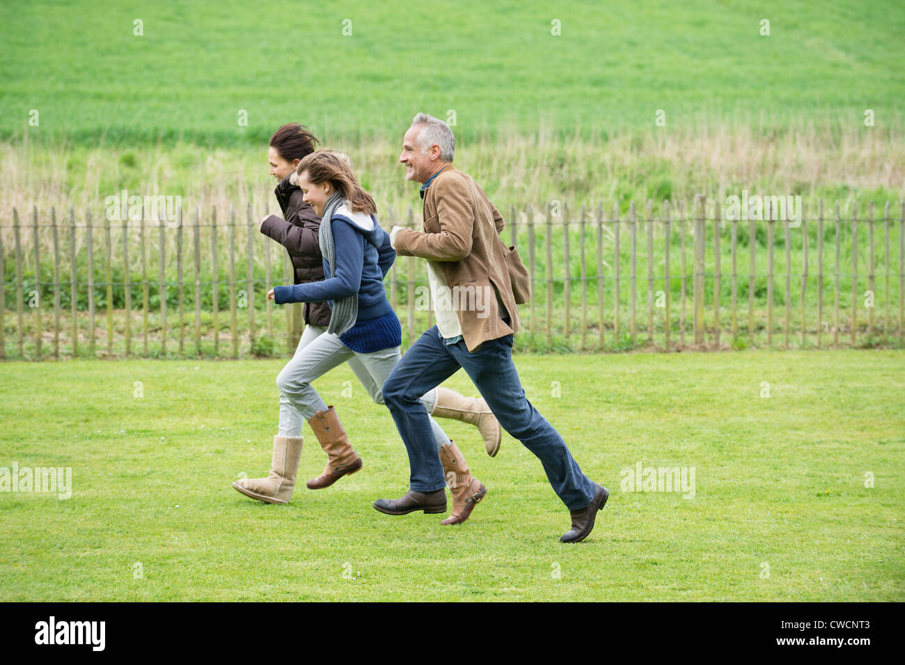Happy family running in a field Stock Photo - Alamy