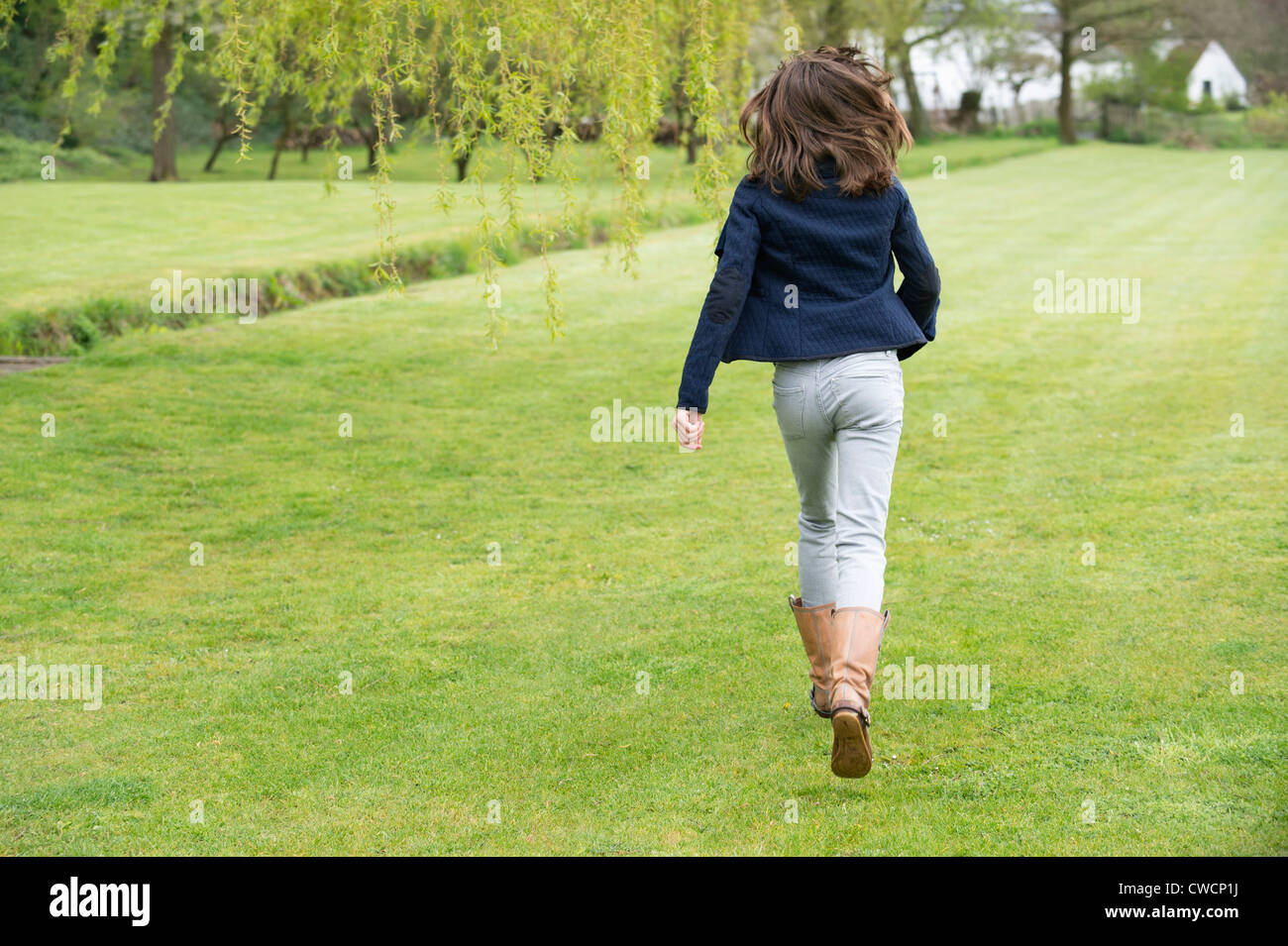 Girl running in a field Stock Photo - Alamy