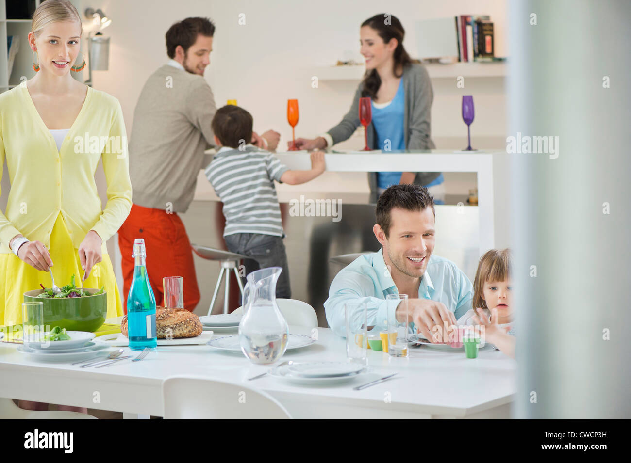 Family setting table for dinner Stock Photo - Alamy