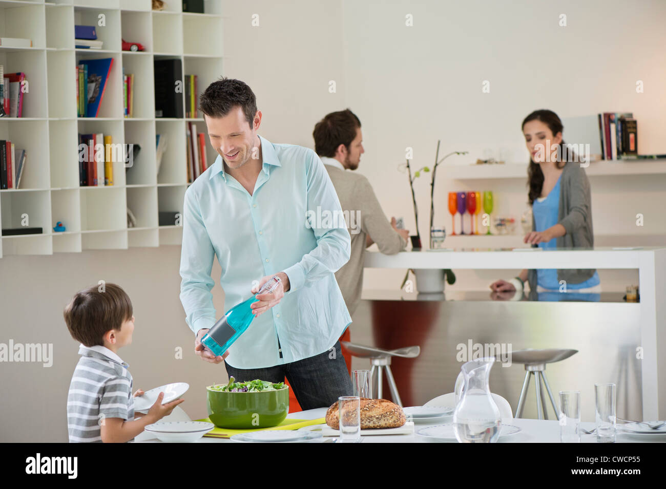 Man and son setting table for lunch Stock Photo - Alamy