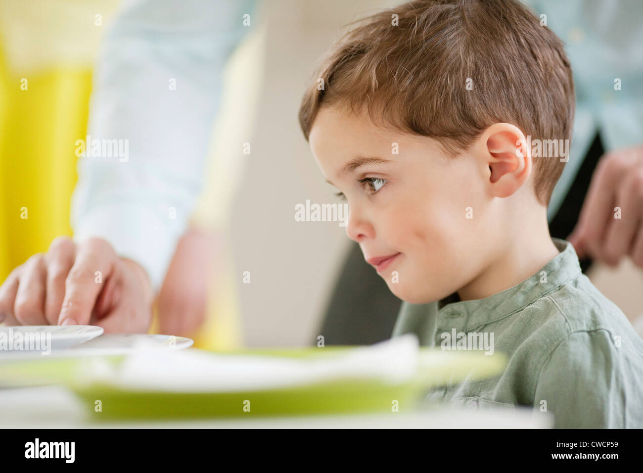 Boy sitting at a dining table Stock Photo - Alamy