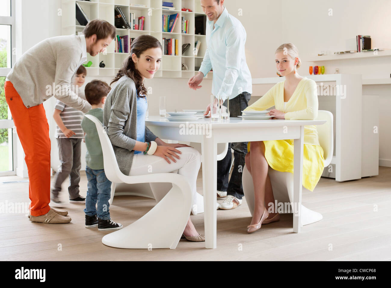 Family at dining table with guests Stock Photo - Alamy