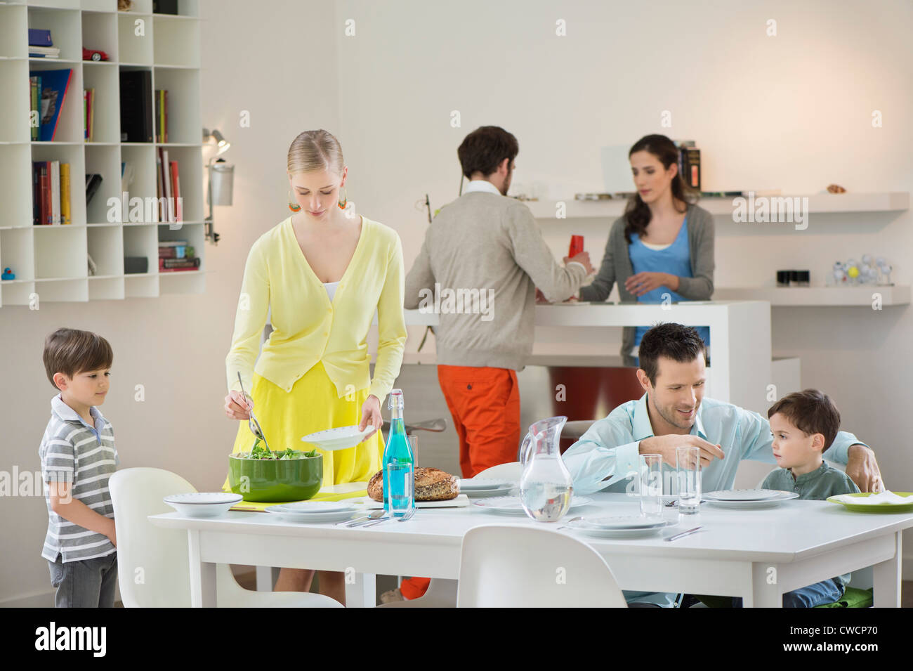 Family setting table for dinner Stock Photo - Alamy