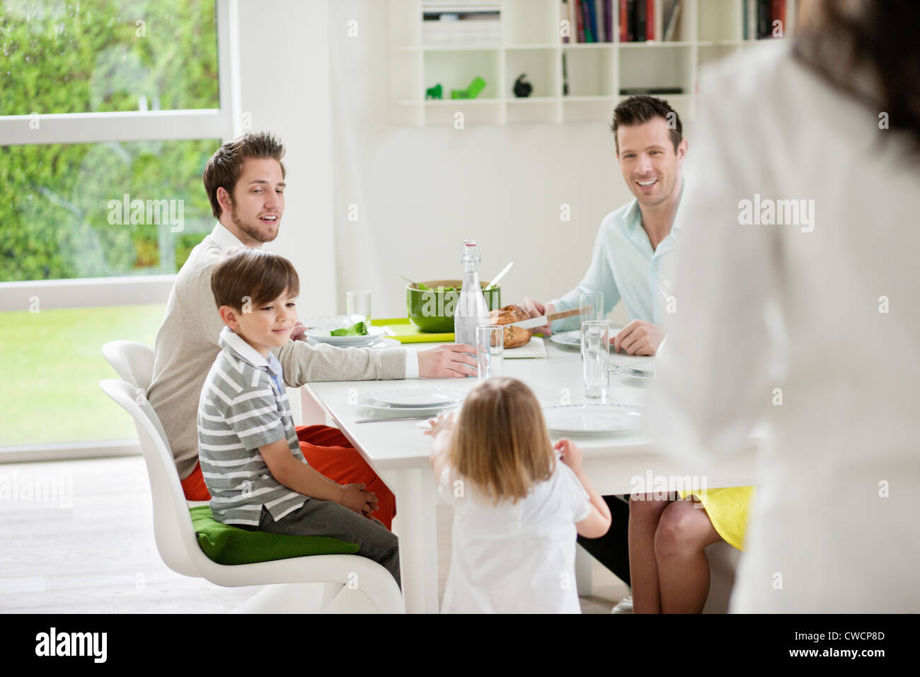 Happy family at dining table Stock Photo - Alamy