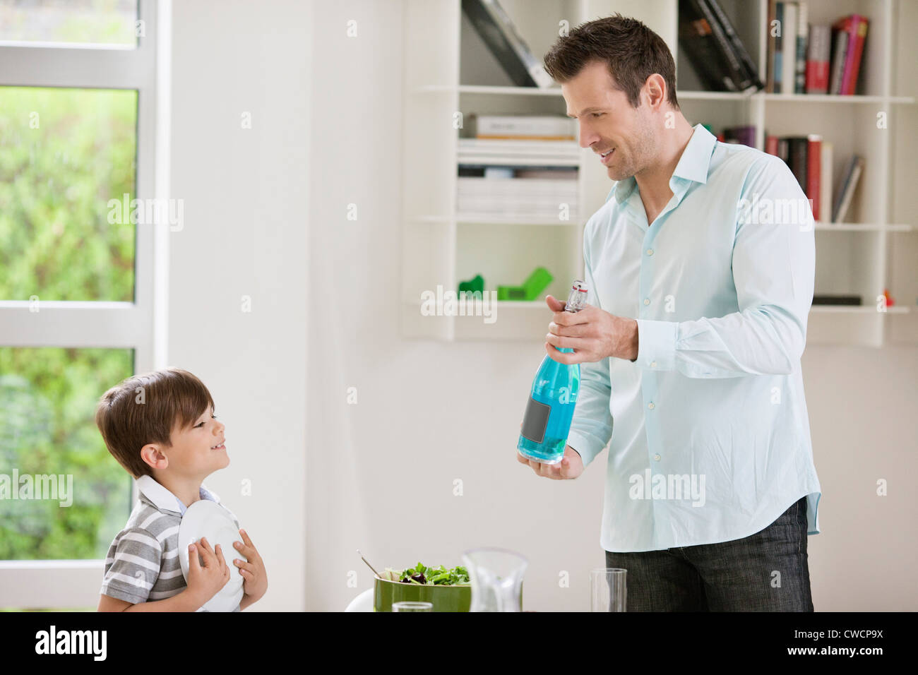 Man showing sparkling water bottle to his son Stock Photo - Alamy