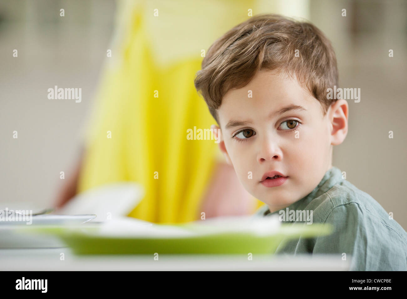 Boy sitting at a dining table Stock Photo - Alamy