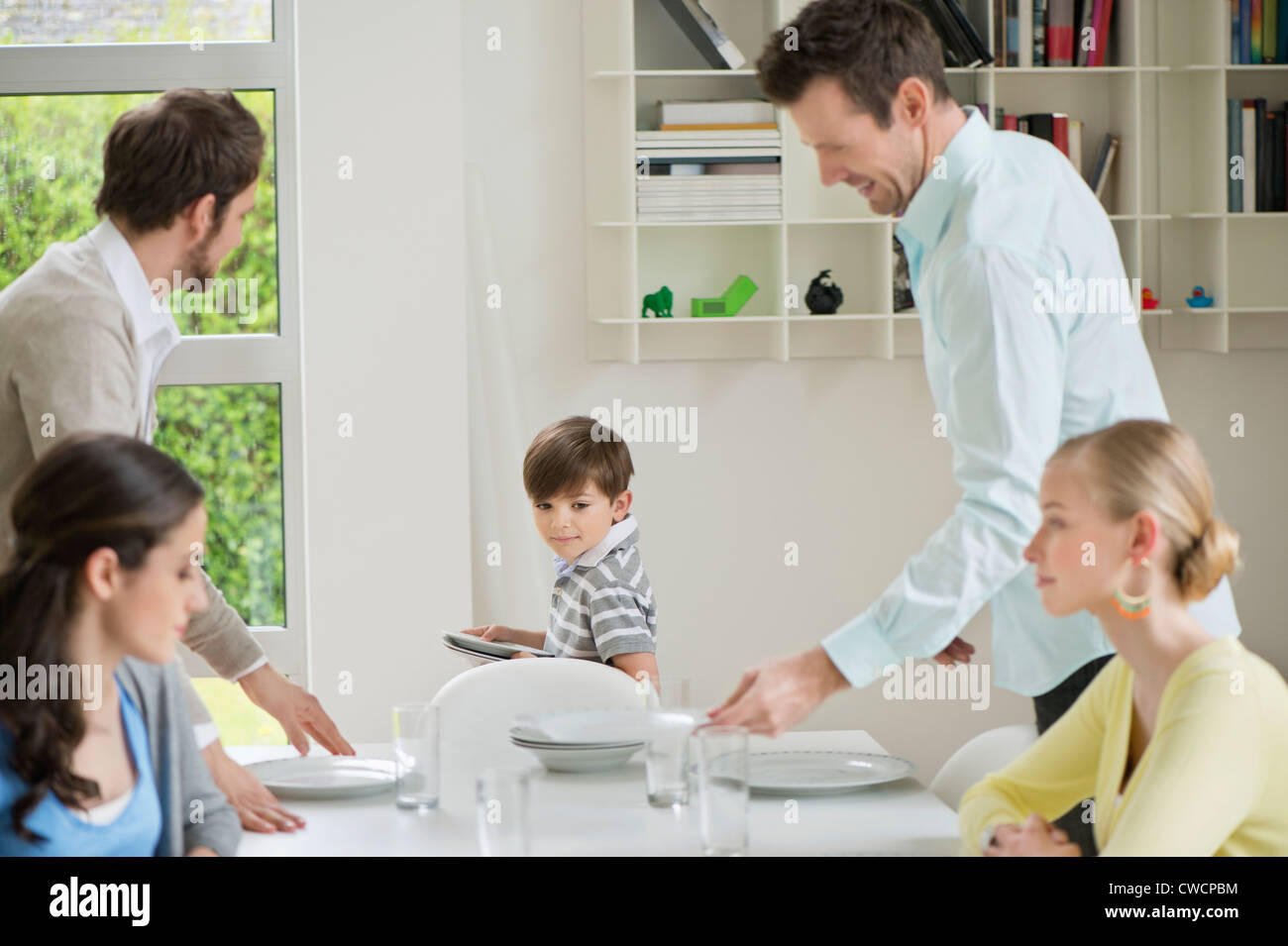 Family and guests at dining table for lunch Stock Photo - Alamy