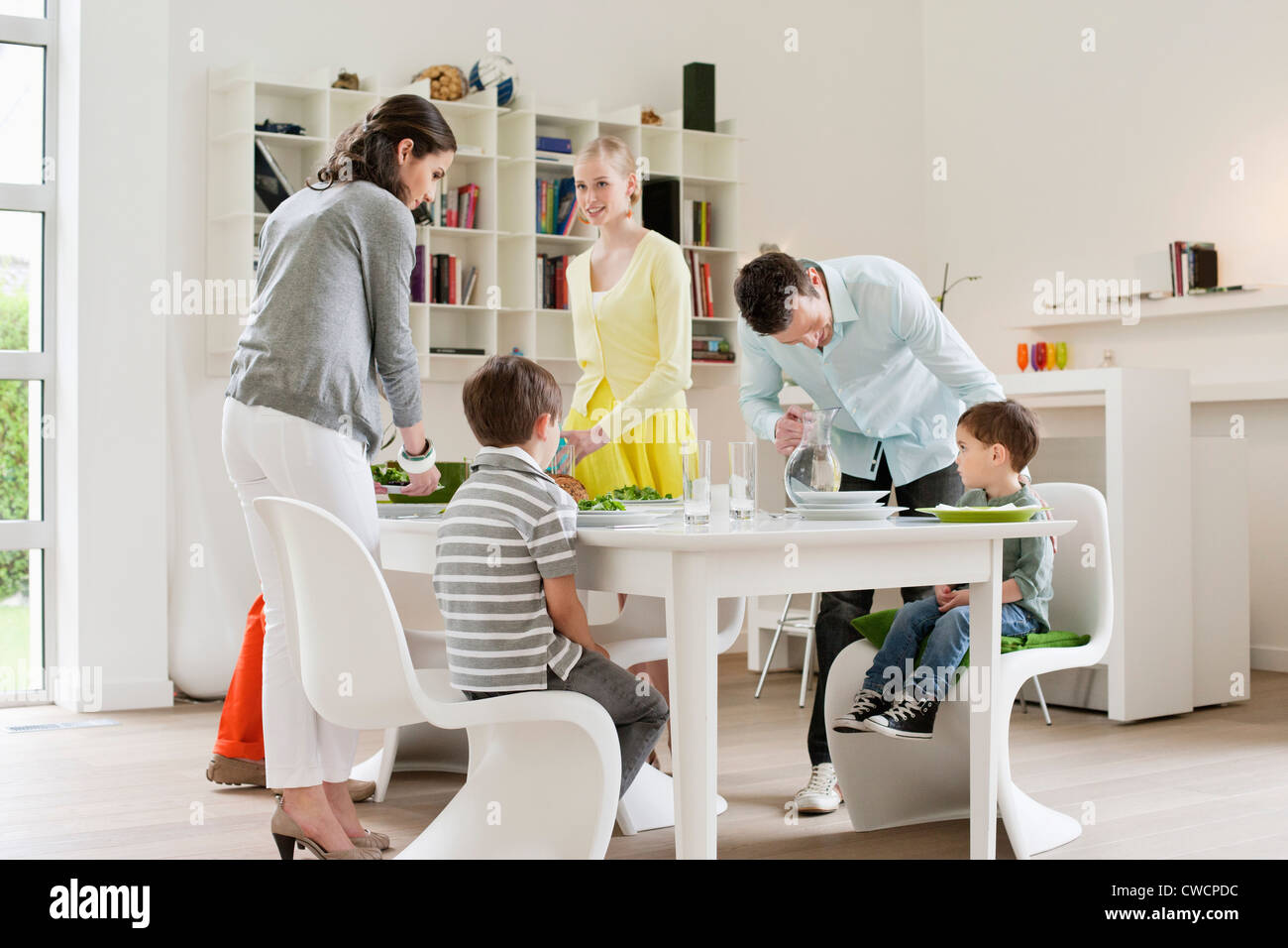 Family at dining table with guests Stock Photo - Alamy