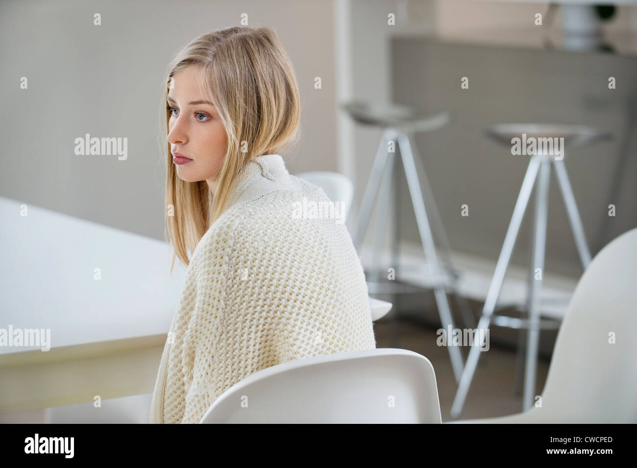 Serious woman sitting in a room Stock Photo - Alamy