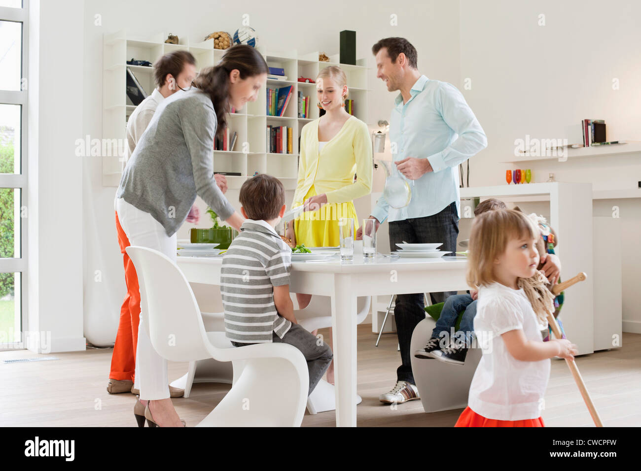 Family at dining table with guests Stock Photo - Alamy