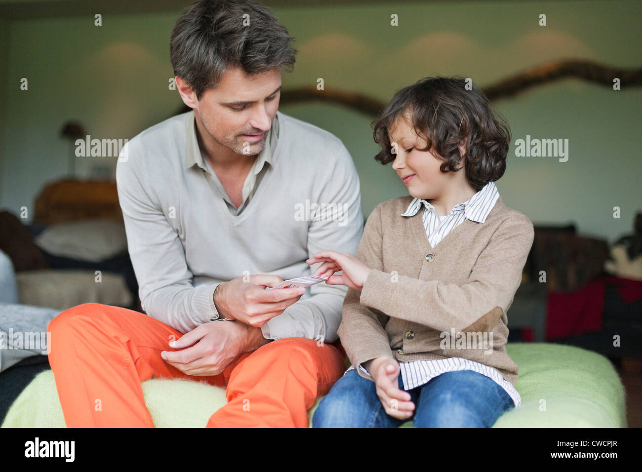 Man playing cards with his son Stock Photo - Alamy