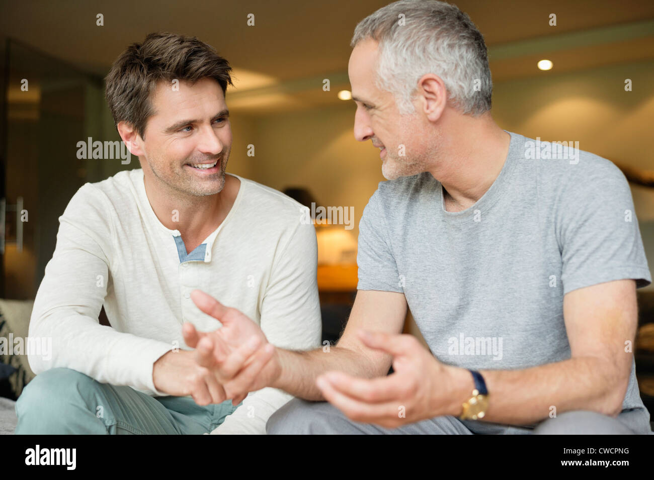 Two male friends discussing and smiling Stock Photo - Alamy