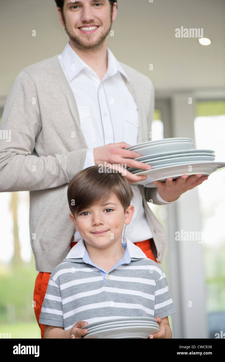 Man and son arranging plates for lunch Stock Photo - Alamy