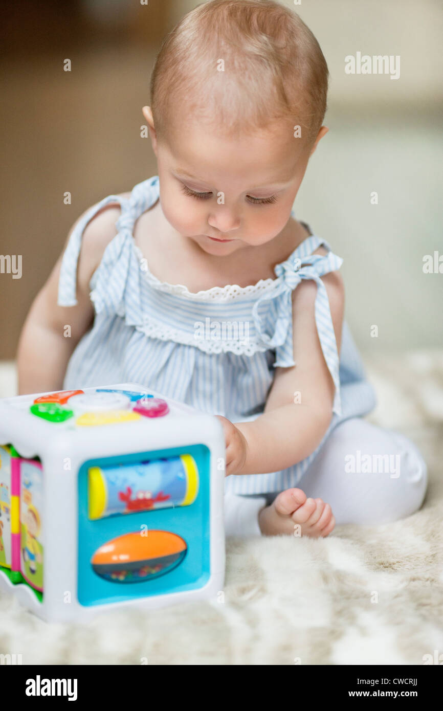Baby girl playing with a musical block toy Stock Photo - Alamy