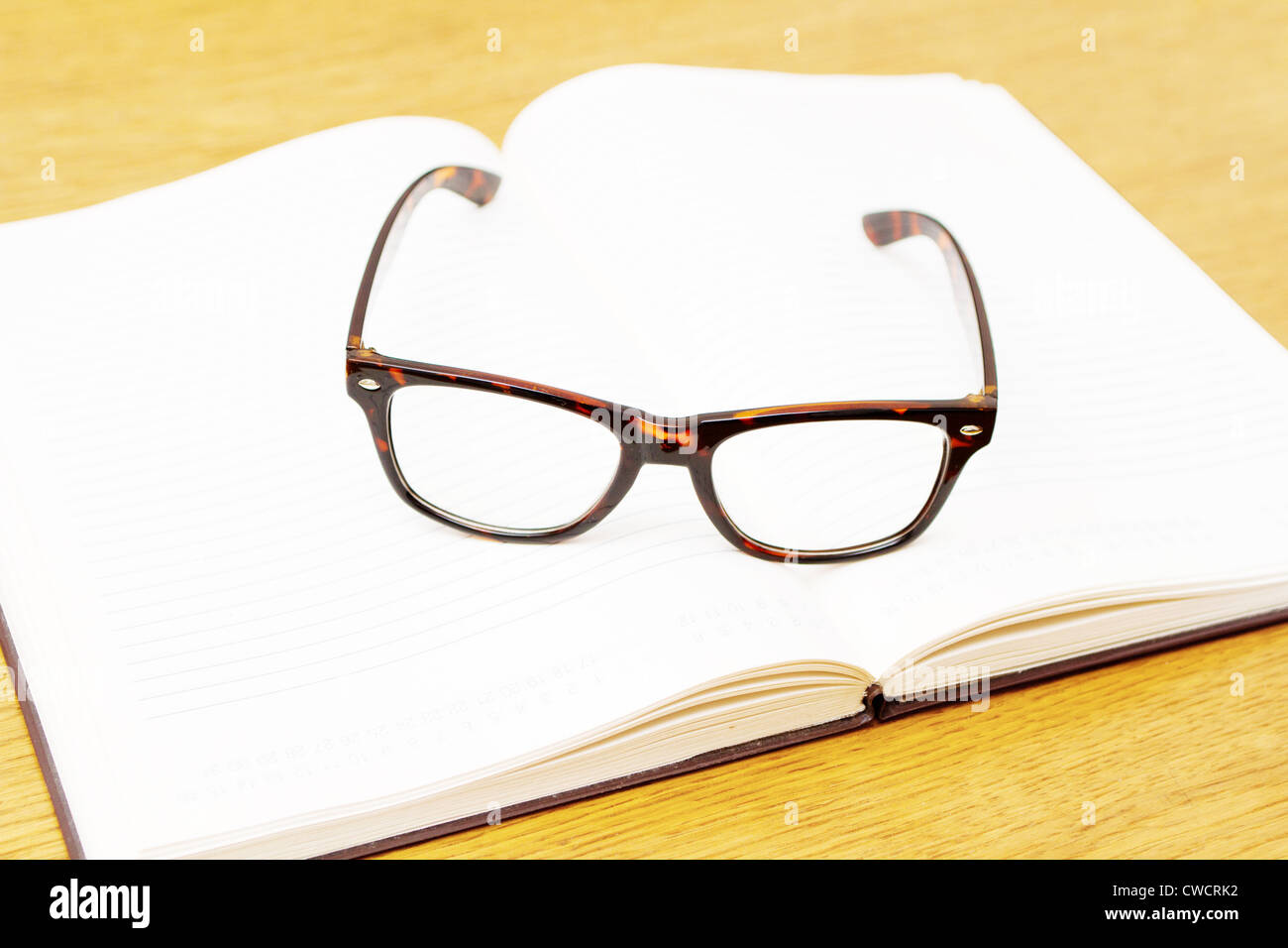 Modern glasses with plastic frames on open book Stock Photo - Alamy