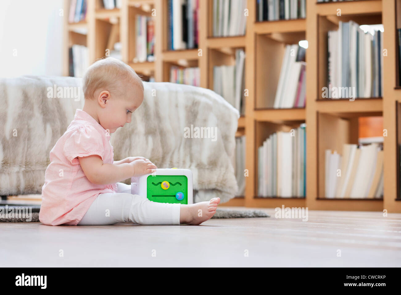 Baby girl playing with a musical block toy Stock Photo - Alamy