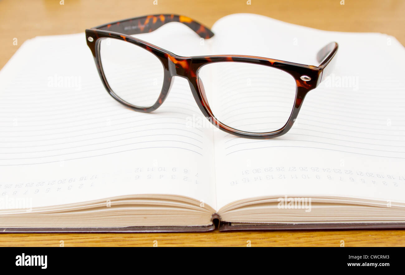 Modern glasses with plastic frames on open book Stock Photo - Alamy