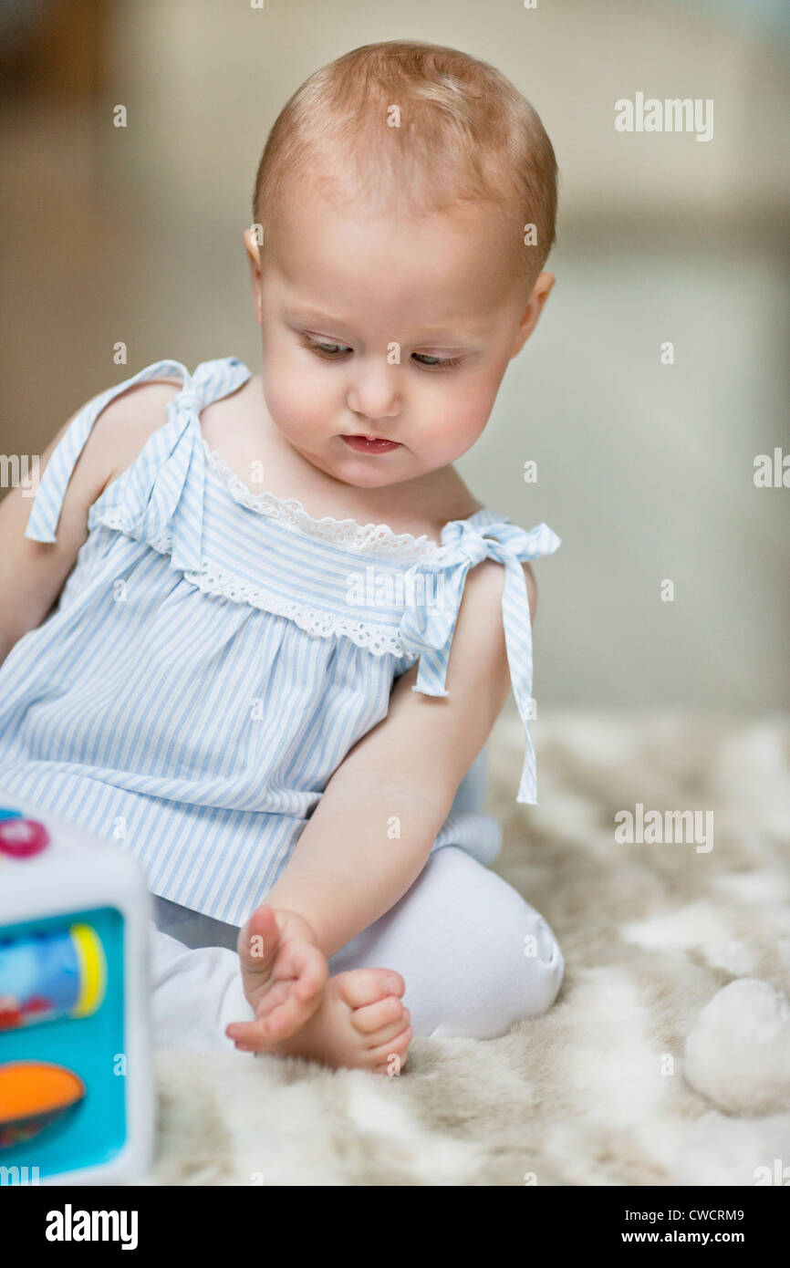 Baby girl playing with a musical block toy Stock Photo - Alamy