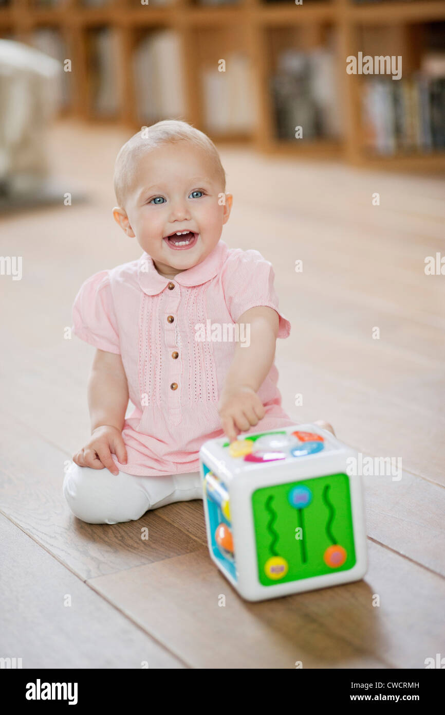 Baby girl playing with a musical block toy Stock Photo - Alamy