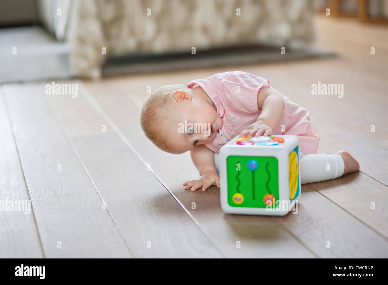 Baby girl playing with a musical block toy Stock Photo - Alamy